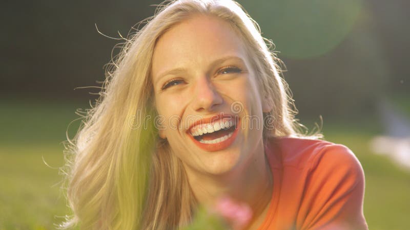 Portrait Attractive Blonde Woman Lies In The Grass And Laughs On A