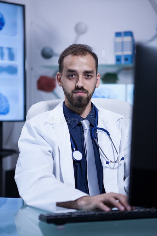 Portrait Of Attractive Caucasian Doctor Looking Into The Camera Sitting