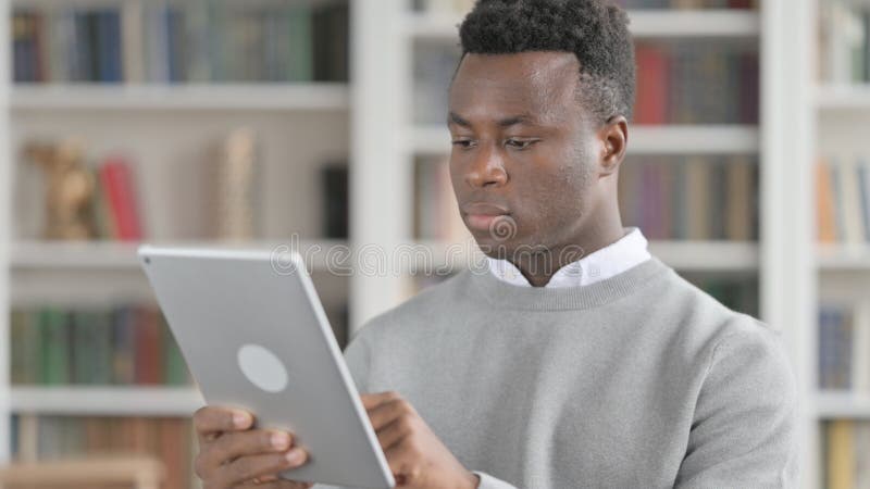Portrait of Attractive African Man Using Tablet in Library Stock Photo ...