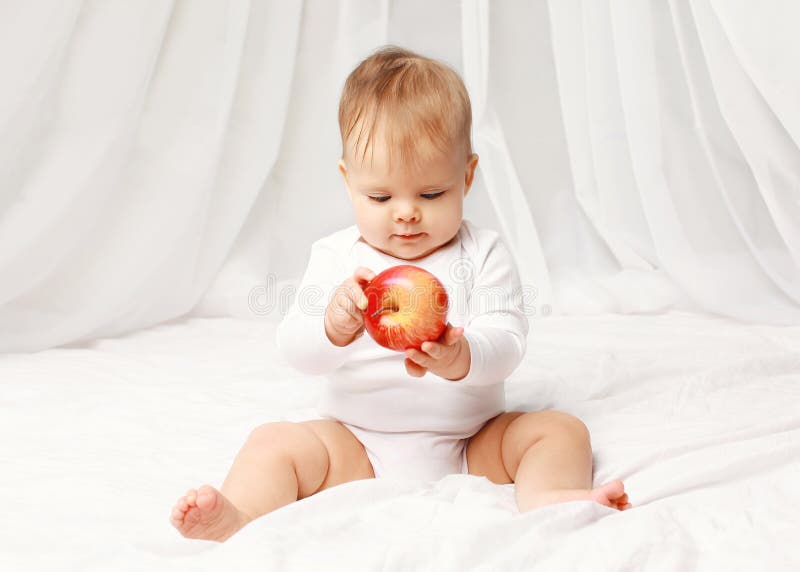 Portrait of Baby Sitting with Red Apple on the Bed Stock Image - Image ...