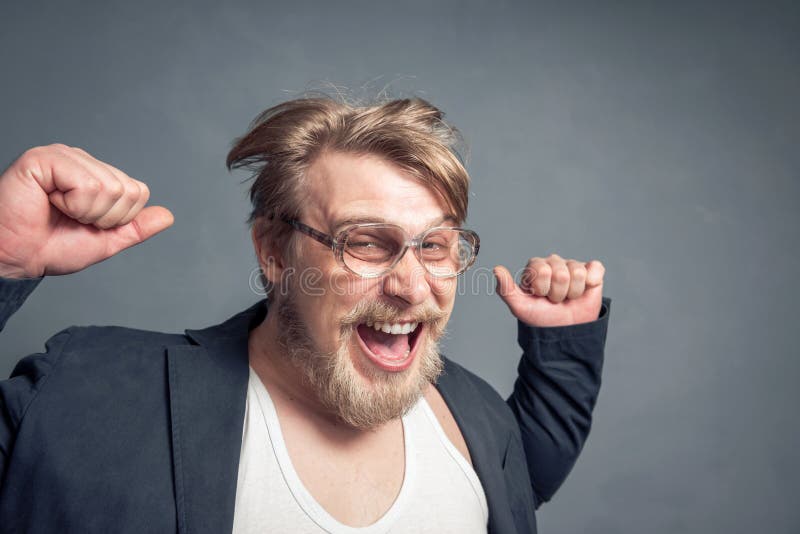 Portrait Of A Bearded Guy In A Hoodie And Hat With His Hands Raised And