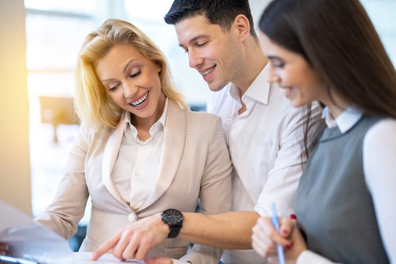 Portrait of Beautiful Business People Analyzing Paper Document Together ...