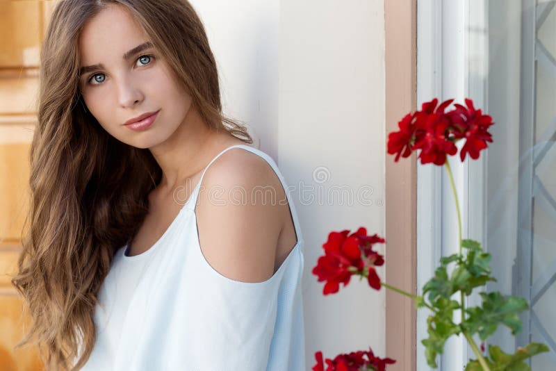 Portrait Of A Beautiful Cute Girl With Blue Eyes And Dark Curly Hair In