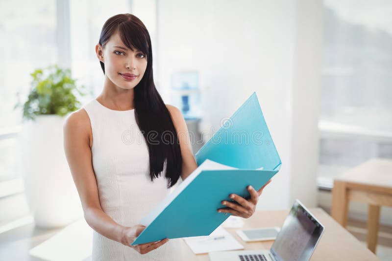 Portrait of Beautiful Executive Holding File at Desk Stock Photo ...