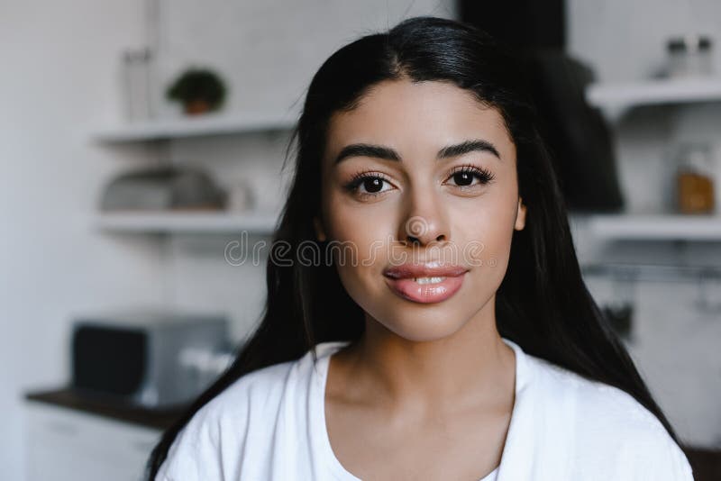 Portrait Of Beautiful Mixed Race Girl In White Robe Looking At Camera