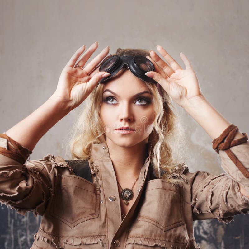 Portrait Of A Beautiful Steampunk Woman In Aviator Glasses Over Grey