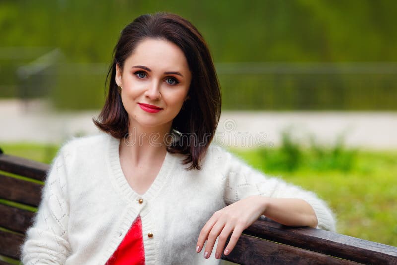 Portrait of a Beautiful Young Lady Sitting on a Bench in a Spring Park ...