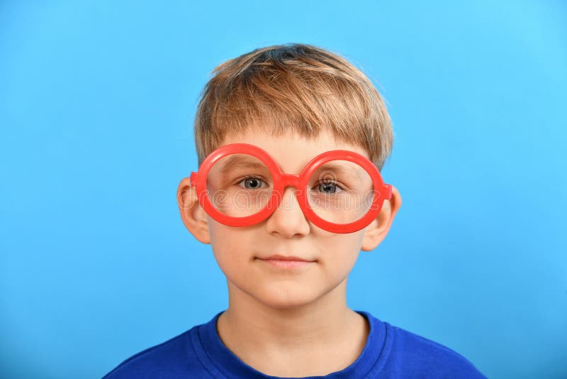 A Portrait of a Boy in Big and Funny Red Glasses Holds Stock Photo ...