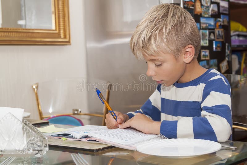 Portrait Of Boy Doing Homework Alone At Kitchen Table At Home ...