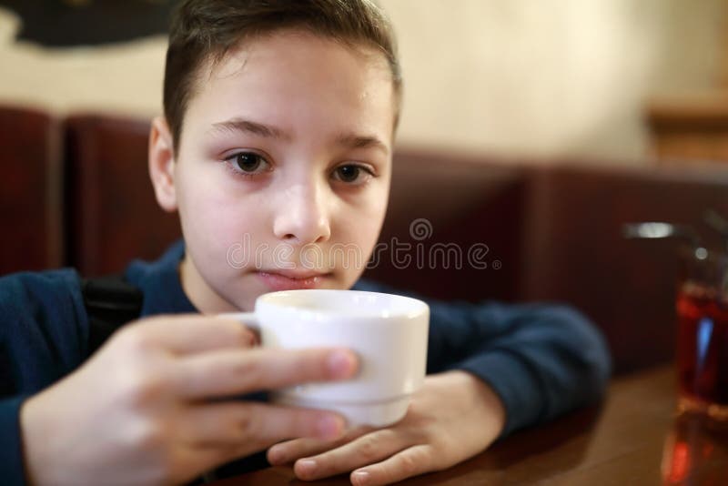 Boy drinking tea in cafe stock image. Image of heat - 242858247