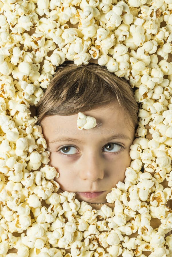 Portrait of a Boy with His Face Surrounded by Popcorn Stock Photo ...