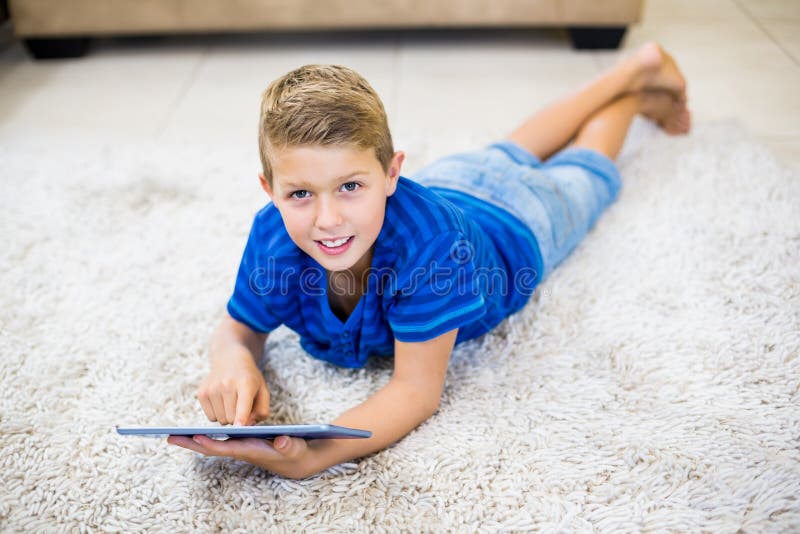 Portrait of Boy Lying on Rug and Using Digital Tablet Stock Image ...