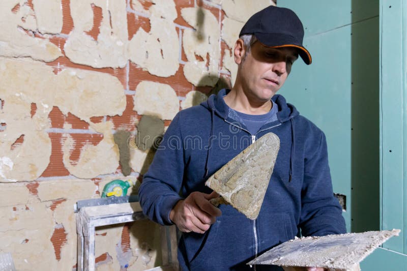 Portrait of a Bricklayer Wearing a Cap, Preparing Tools To Plaster a ...