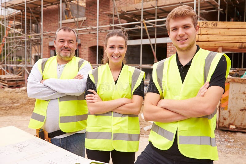 Builder on Building Site Looking at Plans with Apprentices Stock Photo ...