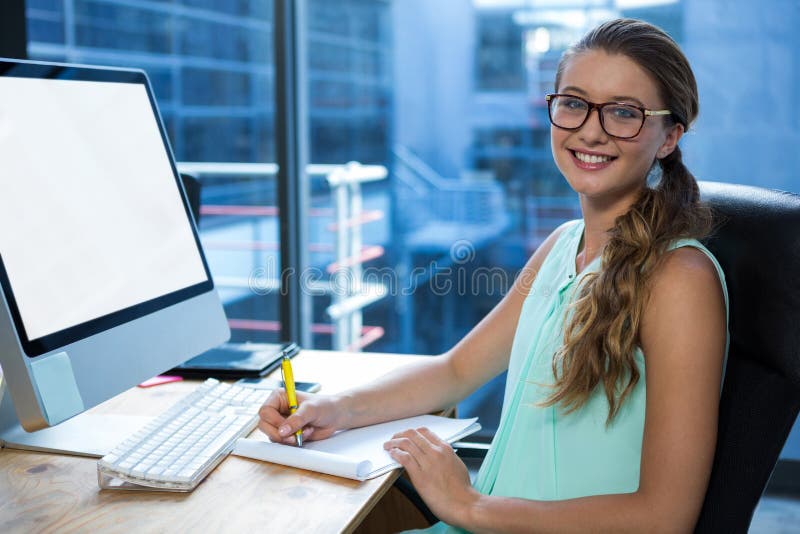 Portrait of Business Executive Writing on Notepad at Desk Stock Photo ...