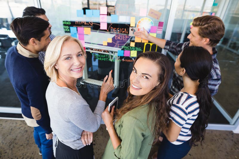Portrait of Business People Standing by Plan on Glass Wall Stock Image ...
