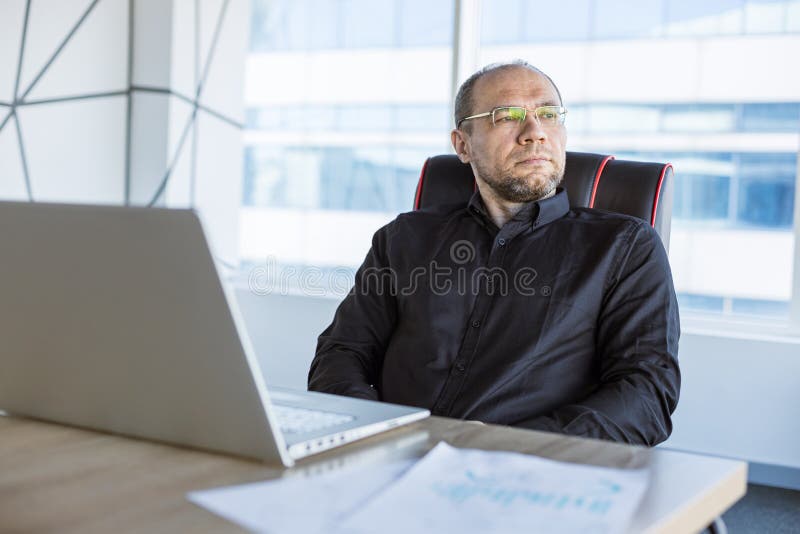 Portrait of a Business Young Successful Man in a Modern Office Sitting ...