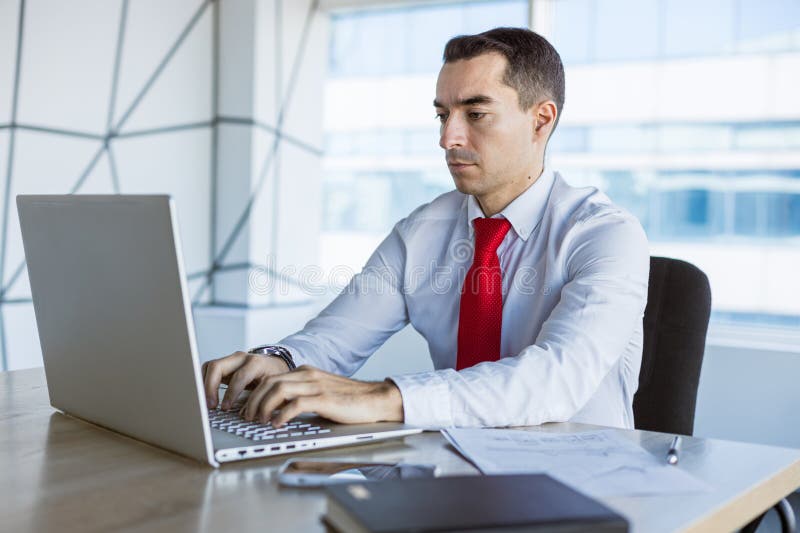 Portrait of a Business Young Successful Man in a Modern Office Sitting ...