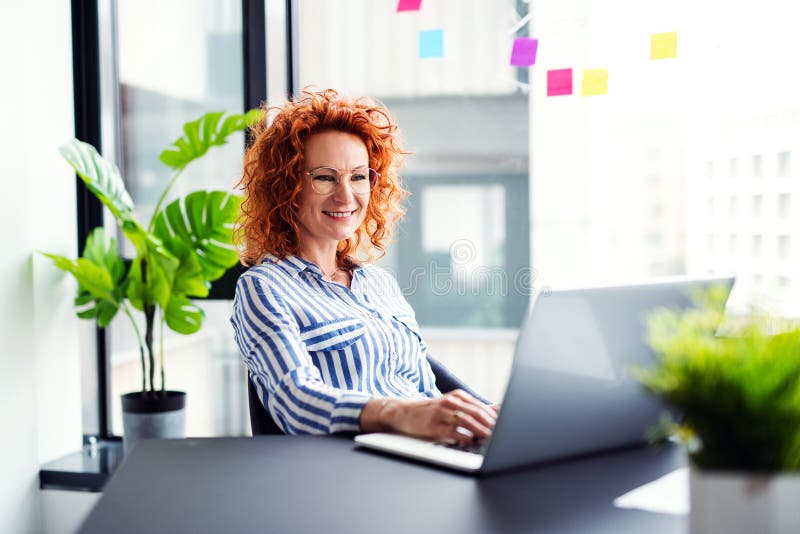 A Portrait of Businesswoman with Computer in an Office, Working. Stock ...