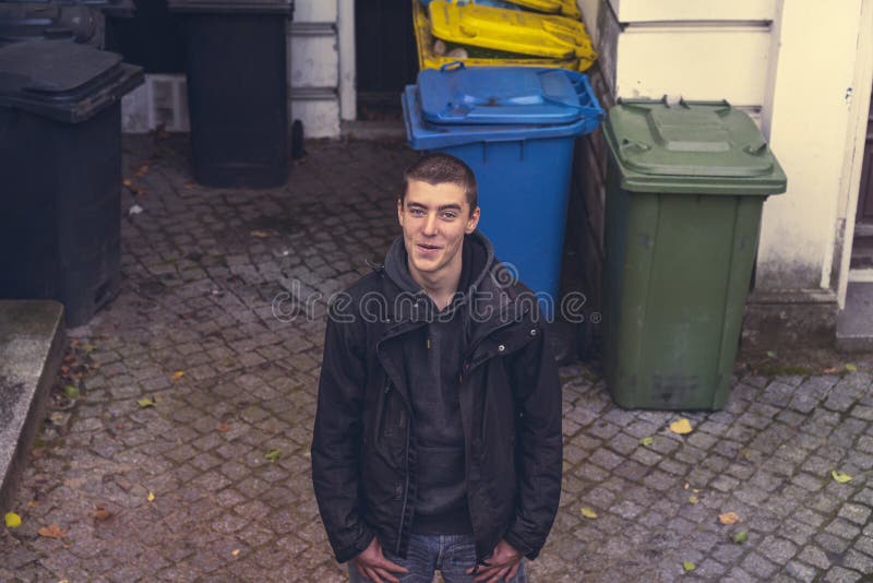 Casual Young Man Standing in Front of Garbage Cans Stock Photo - Image ...