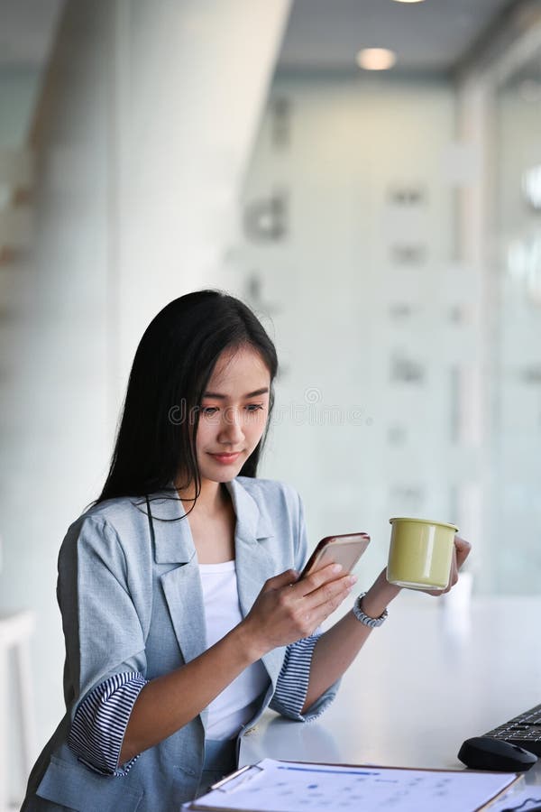 Cheerful Businesswoman Taking a Break in Office and Using Mobile Phone ...