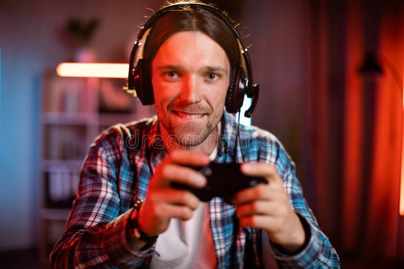 Portrait of Cheerful Caucasian Guy in Headset Using Remote Console for ...