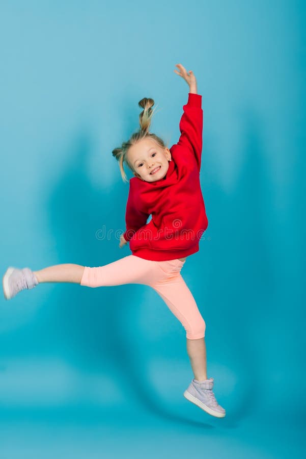 Portrait of a Cheerful Girl Jumping and Dancing Against a Studio ...