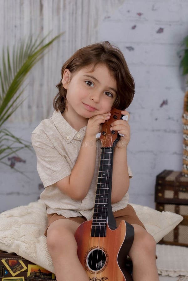 A Vertical Shot of a Young Boy with Its Ukulele Stock Image - Image of ...