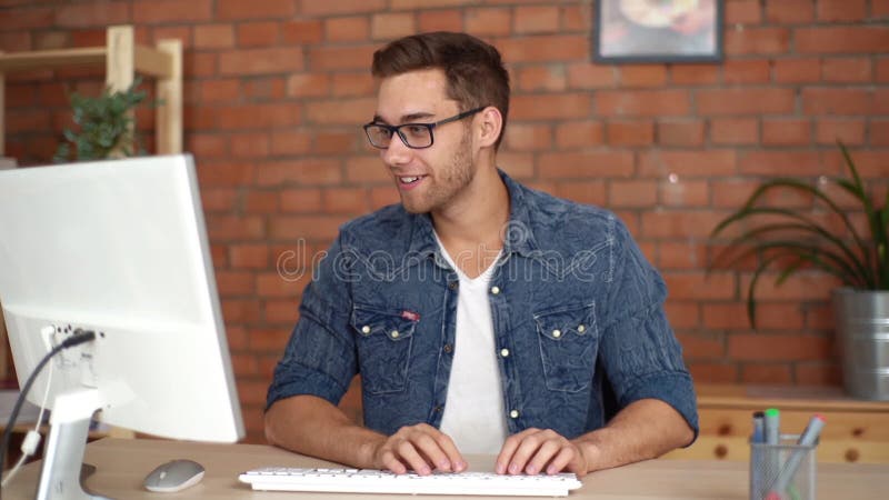 Portrait of Cheerful Young Man Young Man Using Computer and Typing ...