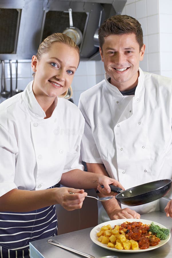 Chef Instructing Trainee In Restaurant Kitchen Stock Image - Image of ...