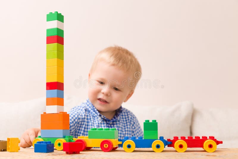 Portrait of Child Playing with Colorful Plastic Bricks at the Table ...