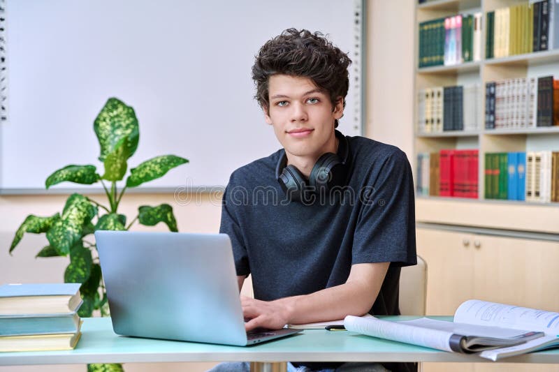 Portrait of College Student Guy Sitting at Desk with Laptop Inside an Educational Library Stock ...