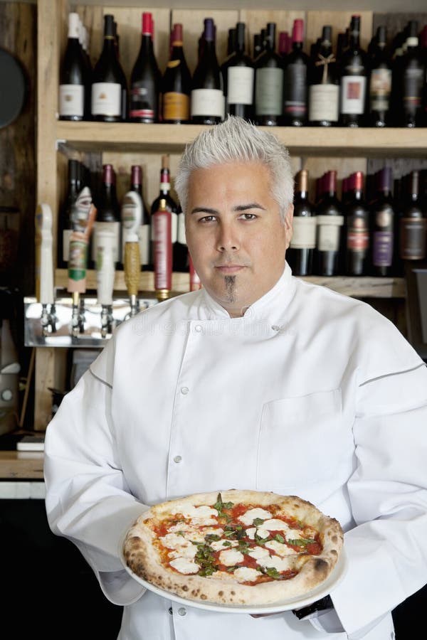 Portrait of a Confident Chef Wearing Headgear while Holding Pizza in ...