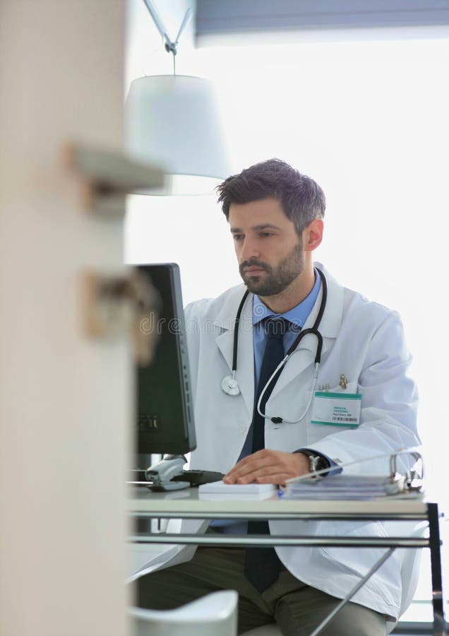 Portrait of Confident Doctor Using Computer at Desk in Hospital Stock ...
