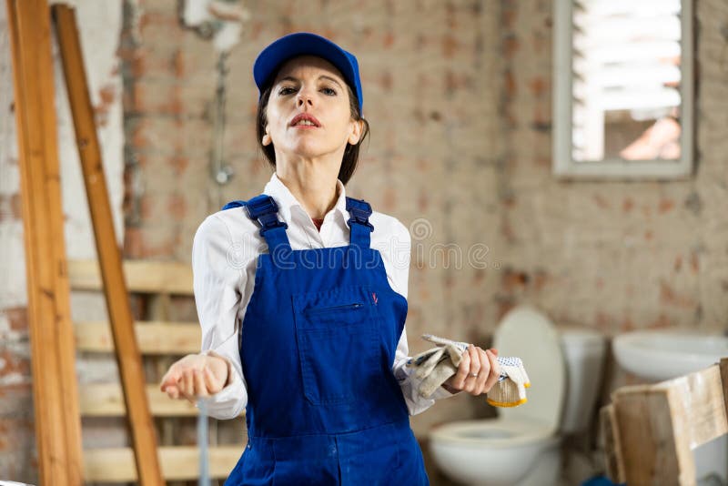 Portrait of Confident Female Foreman in Blue Overalls in Building Under ...
