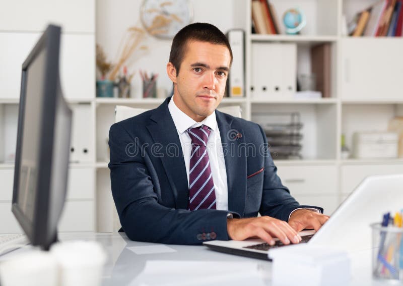 Focused Office Employee Working with Laptop and Documents Stock Photo ...