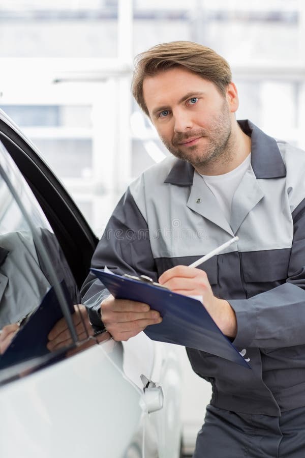 Mechanic Leaning Over Car Window in Garage Stock Photo - Image of chevy ...