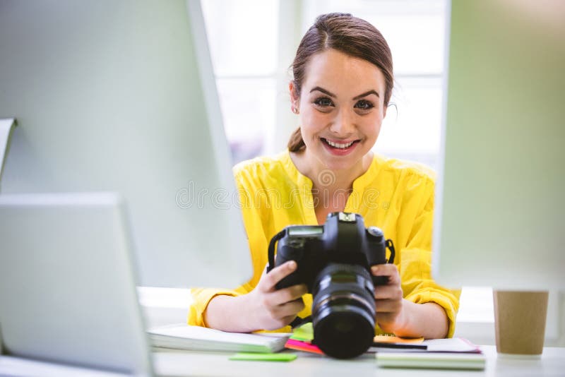 Portrait of Confident Professional with Digital Camera and Computer at ...