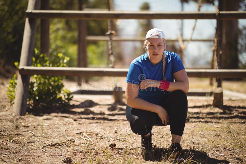 Portrait of Confident Woman Crouching in Boot Camp Stock Photo - Image ...