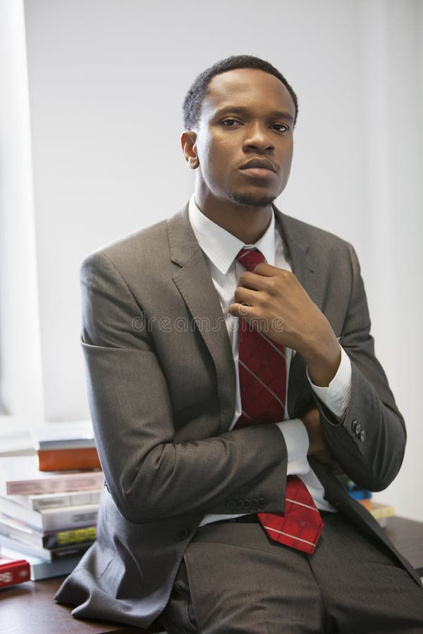 Portrait of a Confident Young Businessman Sitting on Desk Stock Image ...