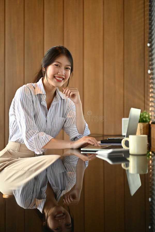 Portrait of Confident Young Businesswoman Using Laptop Computer at ... Portrait of Confident Young Businesswoman Using Laptop Computer at ...