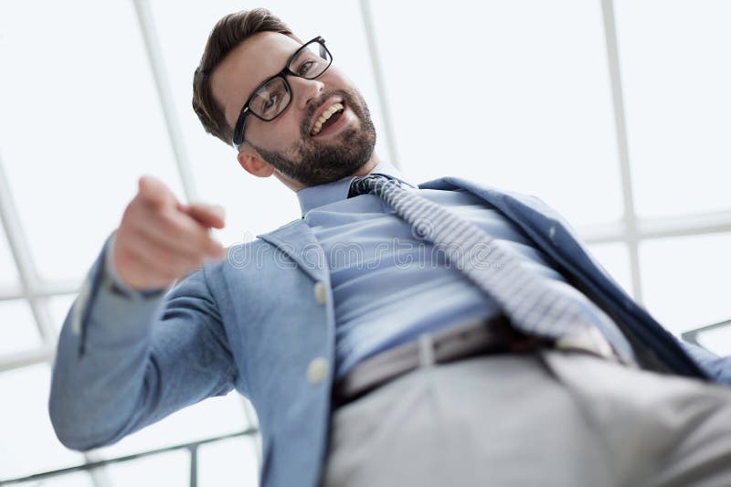 Portrait of a Confident Young Man in Glasses Pointing His Finger Down ... Portrait of a Confident Young Man in Glasses Pointing His Finger Down ...