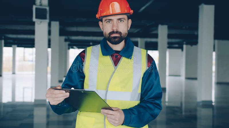 Portrait of Construction Specialist Standing in Workplace with Papers ...