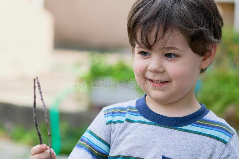 Portrait of a Cute Baby Boy Playing with a Stick in the Backyard Stock ...