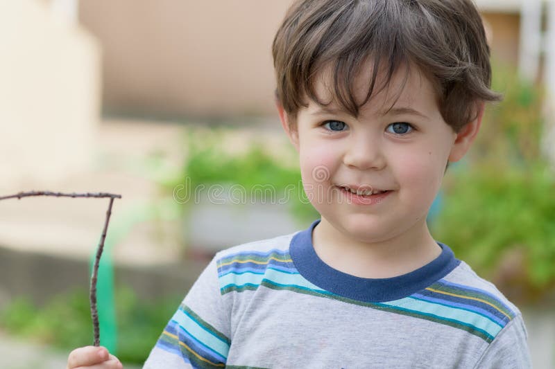 Portrait of a Cute Baby Boy Playing with a Stick in the Backyard Stock ...