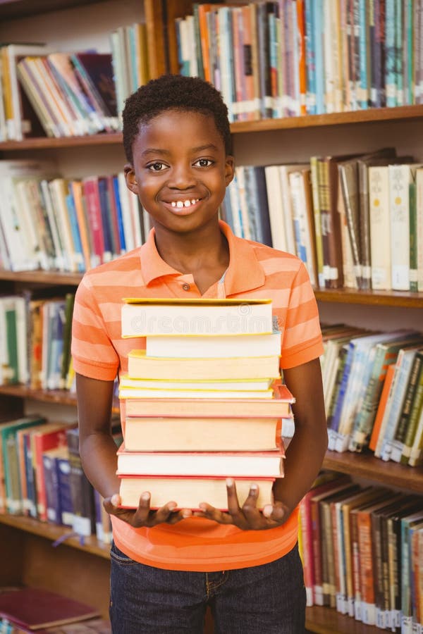 Portrait of Cute Boy Carrying Books in Library Stock Photo - Image of ...