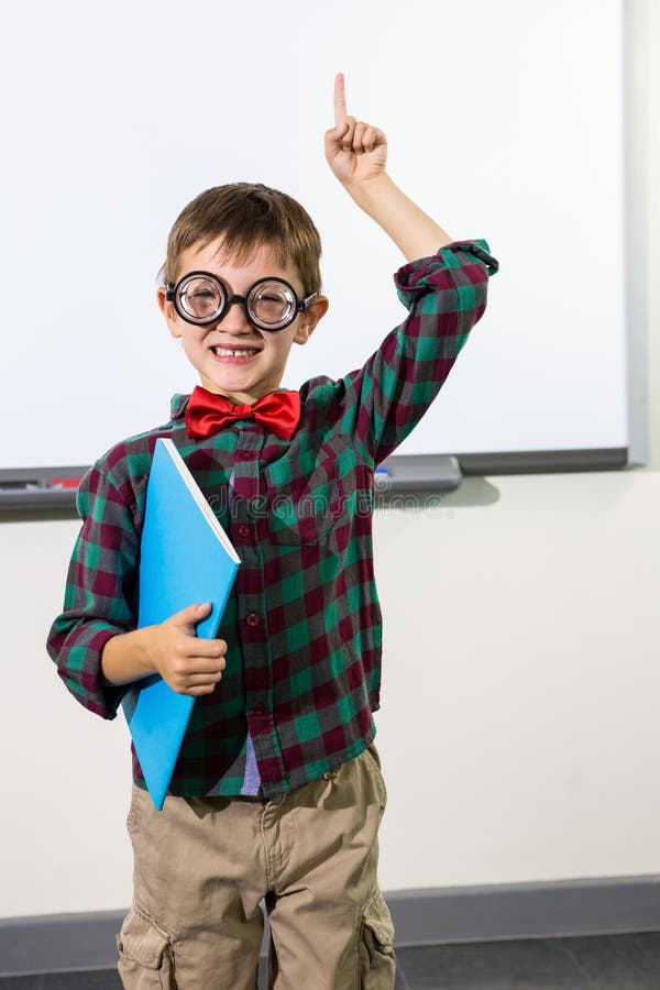 Portrait of Cute Boy with Notebook Raising Hand in Classroom Stock ...