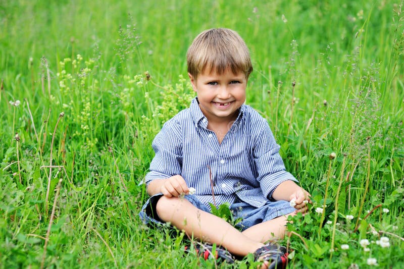 Portrait of Cute Boy Sitting on Green Grass Stock Photo - Image of ...