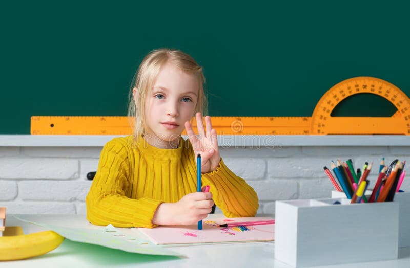 Portrait of Cute Little Schoolgirl Writing in Book with Classmates in ... Portrait of Cute Little Schoolgirl Writing in Book with Classmates in ...