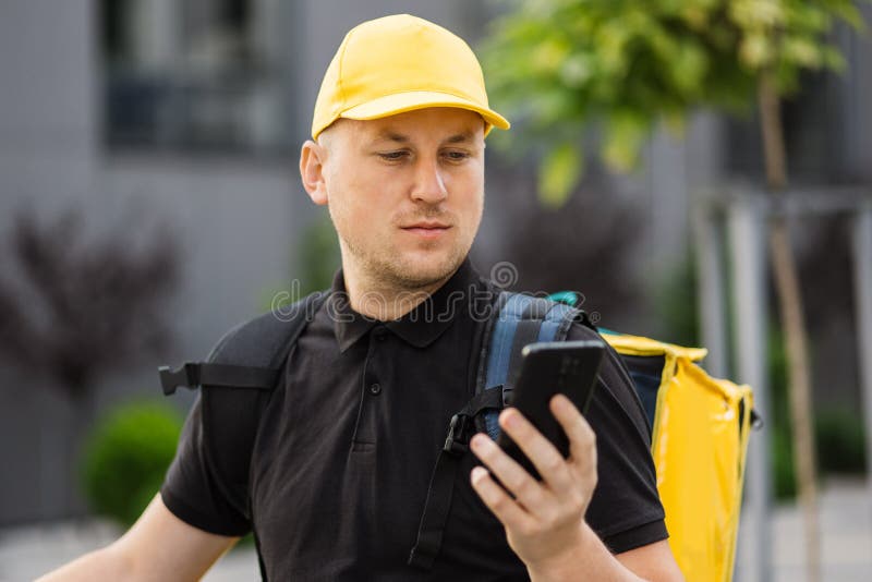 Portrait of Delivery Man in Yellow Cap with Thermo Backpack Checking ...